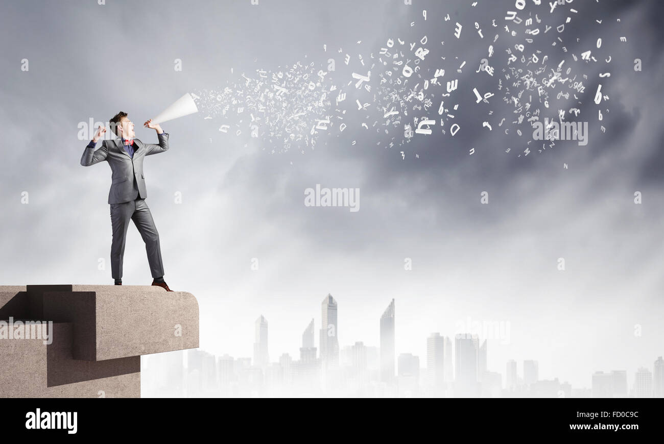Young excited businessman screaming in paper trumpet Stock Photo - Alamy
