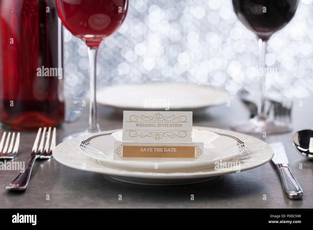 Luxurious wedding invitation placed on a table with wine glasses and ...