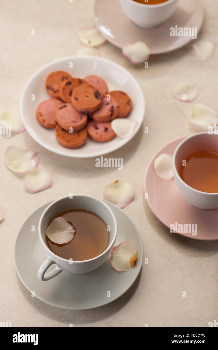 High angle of a set of tea tale with cookies and petal decoration Stock ...
