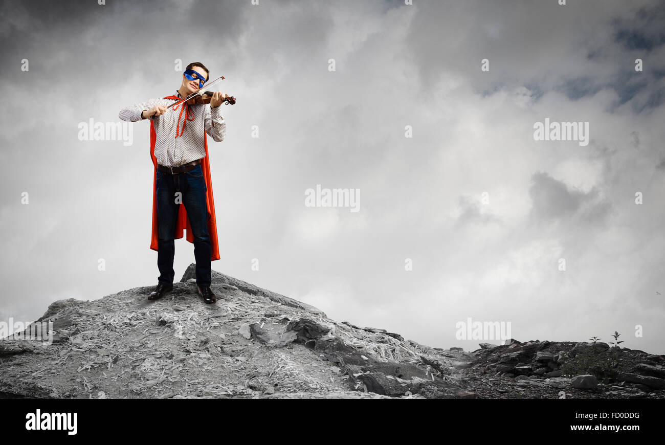 Young man in superhero costume playing violin hi-res stock photography ...