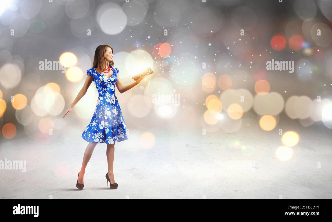 Young woman in blue dress reading book Stock Photo - Alamy