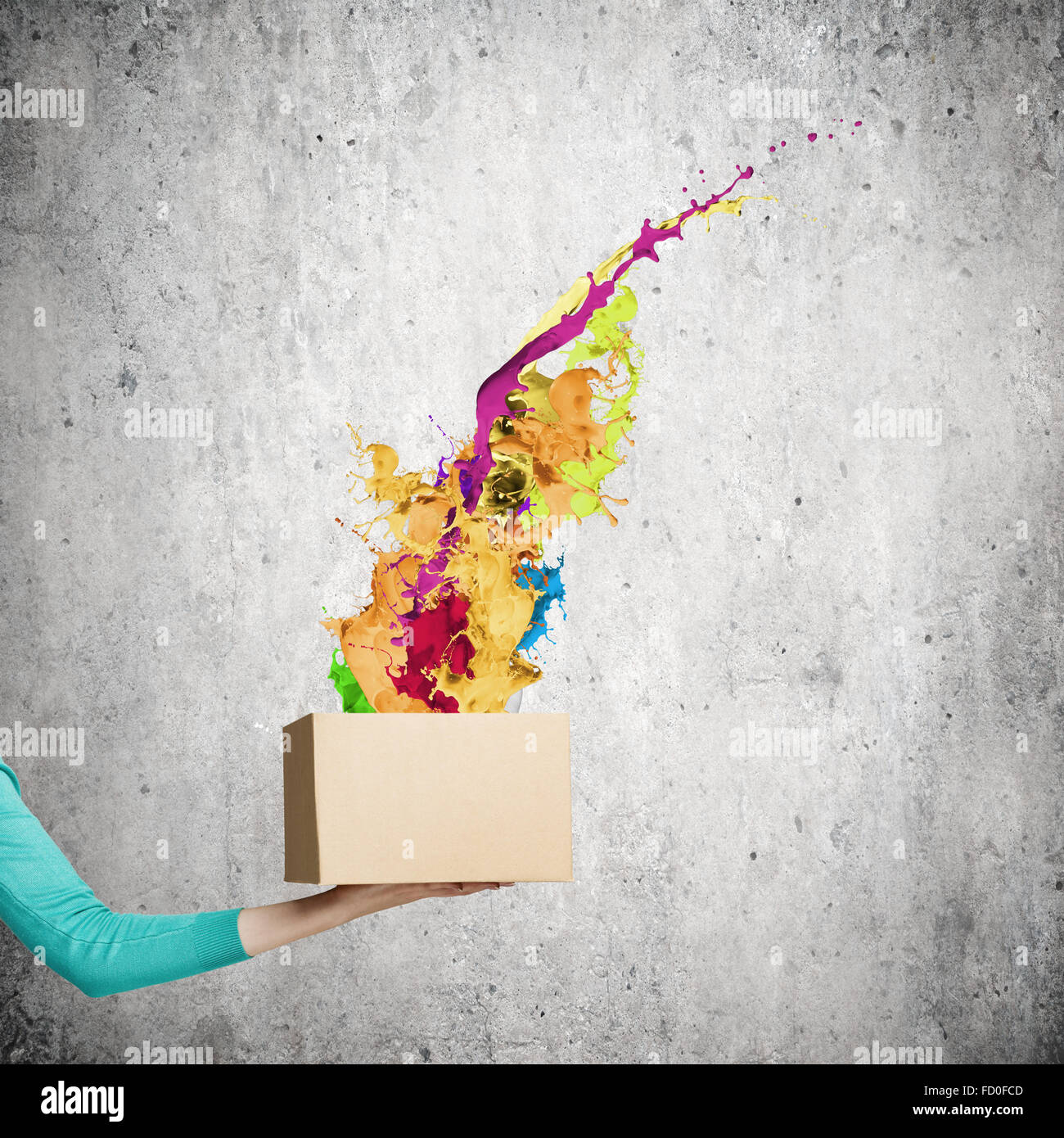 Close up of female hand holding carton box with colorful splashes Stock ...