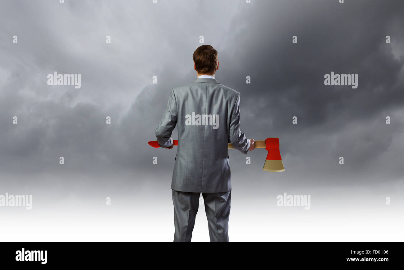 Rear view of young determined businessman with axe in hands Stock Photo ...
