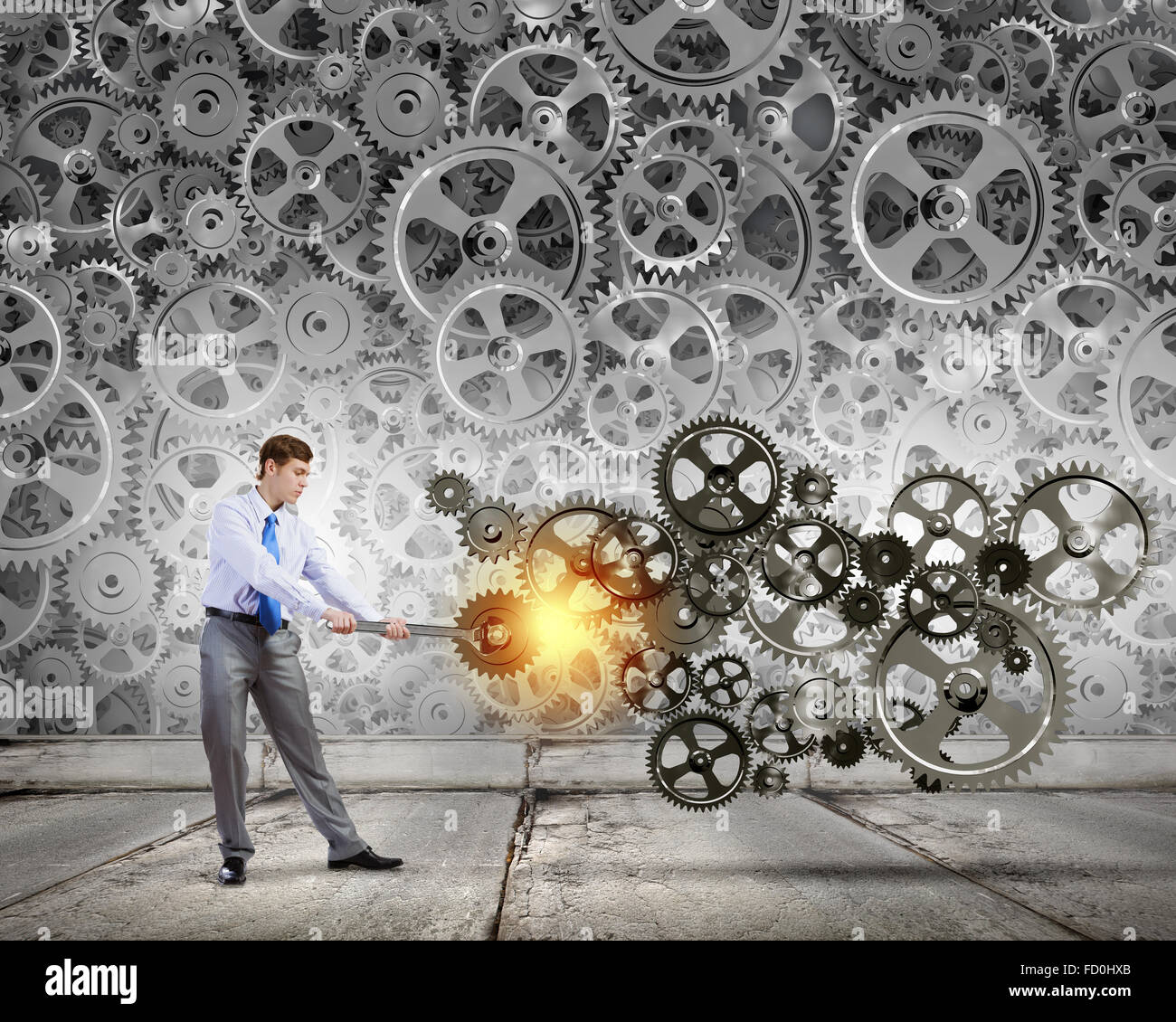 Young determined businessman with wrench fixing mechanism Stock Photo ...