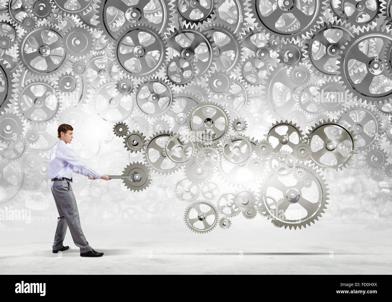 Young determined businessman with wrench fixing mechanism Stock Photo ...