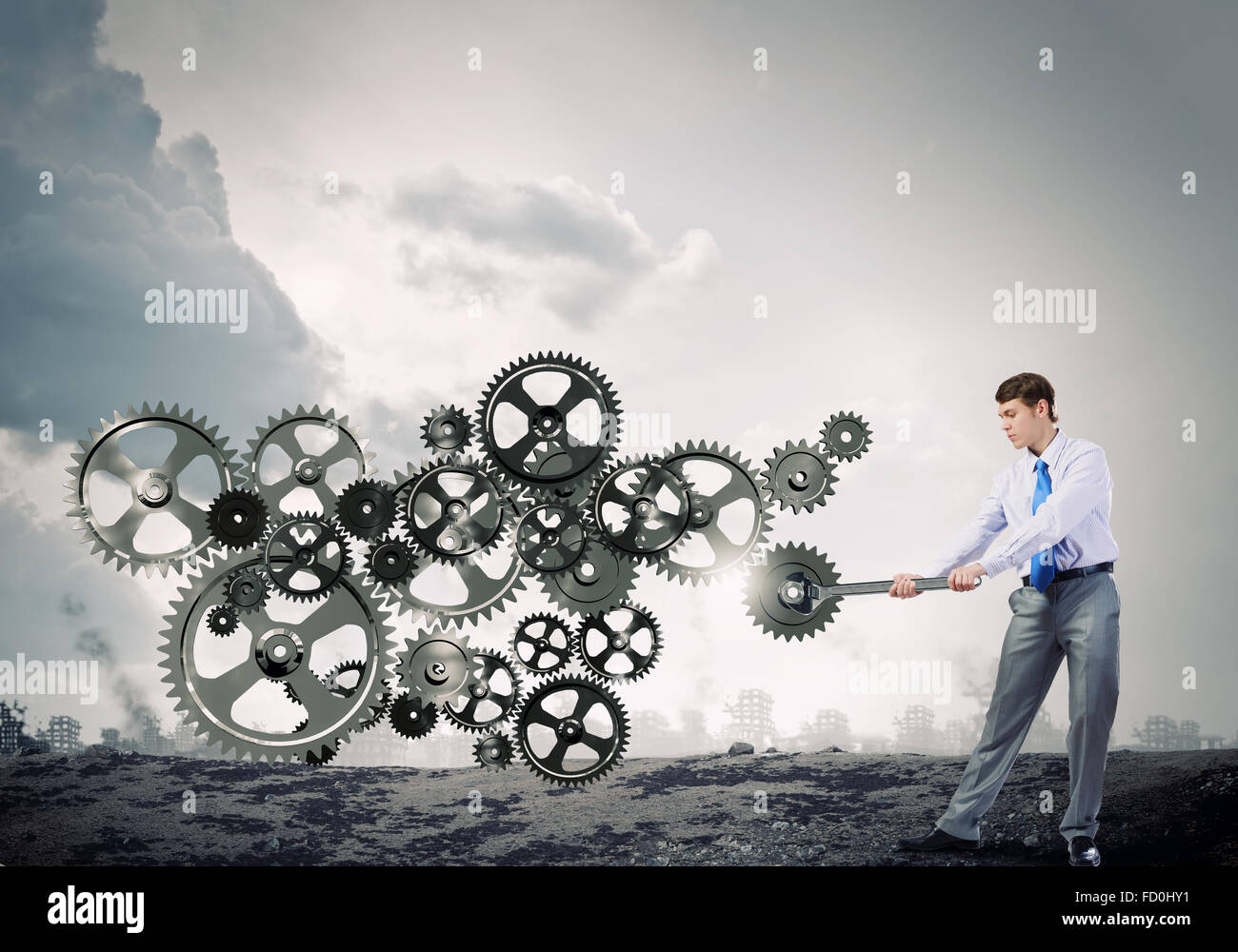 Young determined businessman with wrench fixing mechanism Stock Photo ...