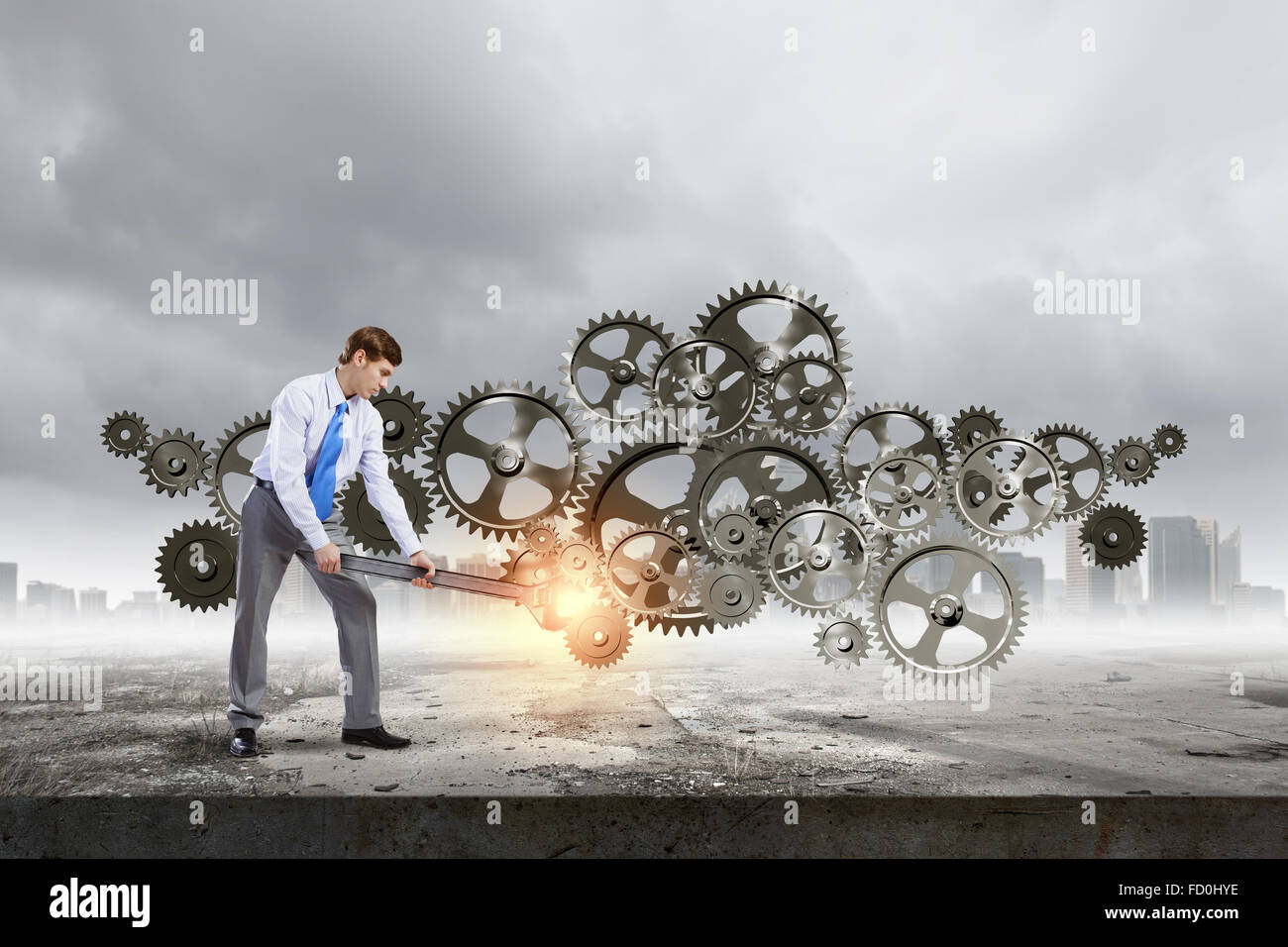 Young determined businessman with wrench fixing mechanism Stock Photo ...