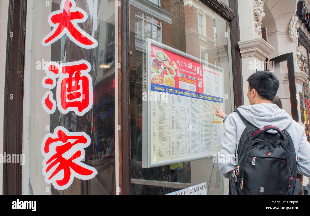 Two Chinese people looking to a menu in a Chinese restaurant in China ...