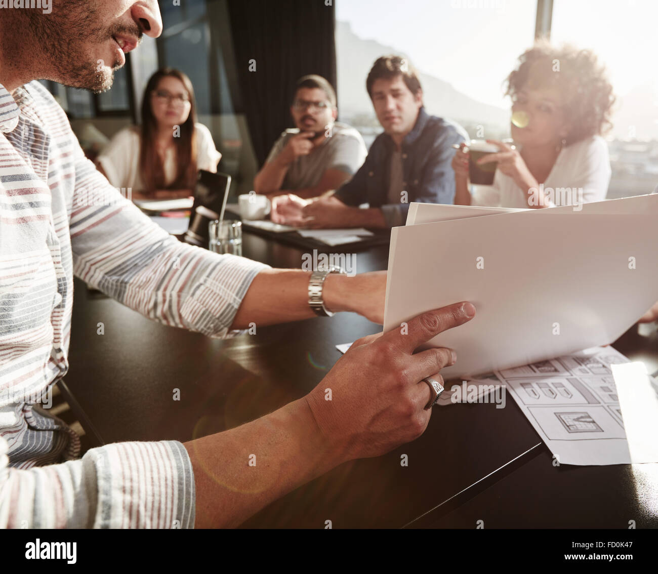 Closeup of hands of young man explaining business plan to colleagues ...