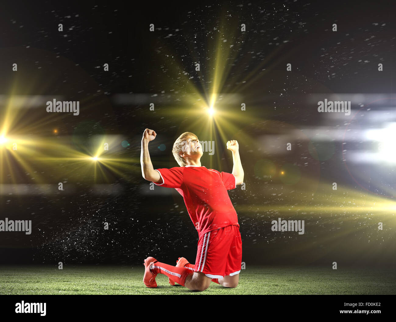 Football player standing on knees and screaming with joy Stock Photo ...