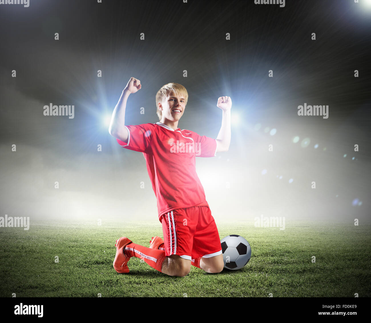 Football player standing on knees and screaming with joy Stock Photo ...