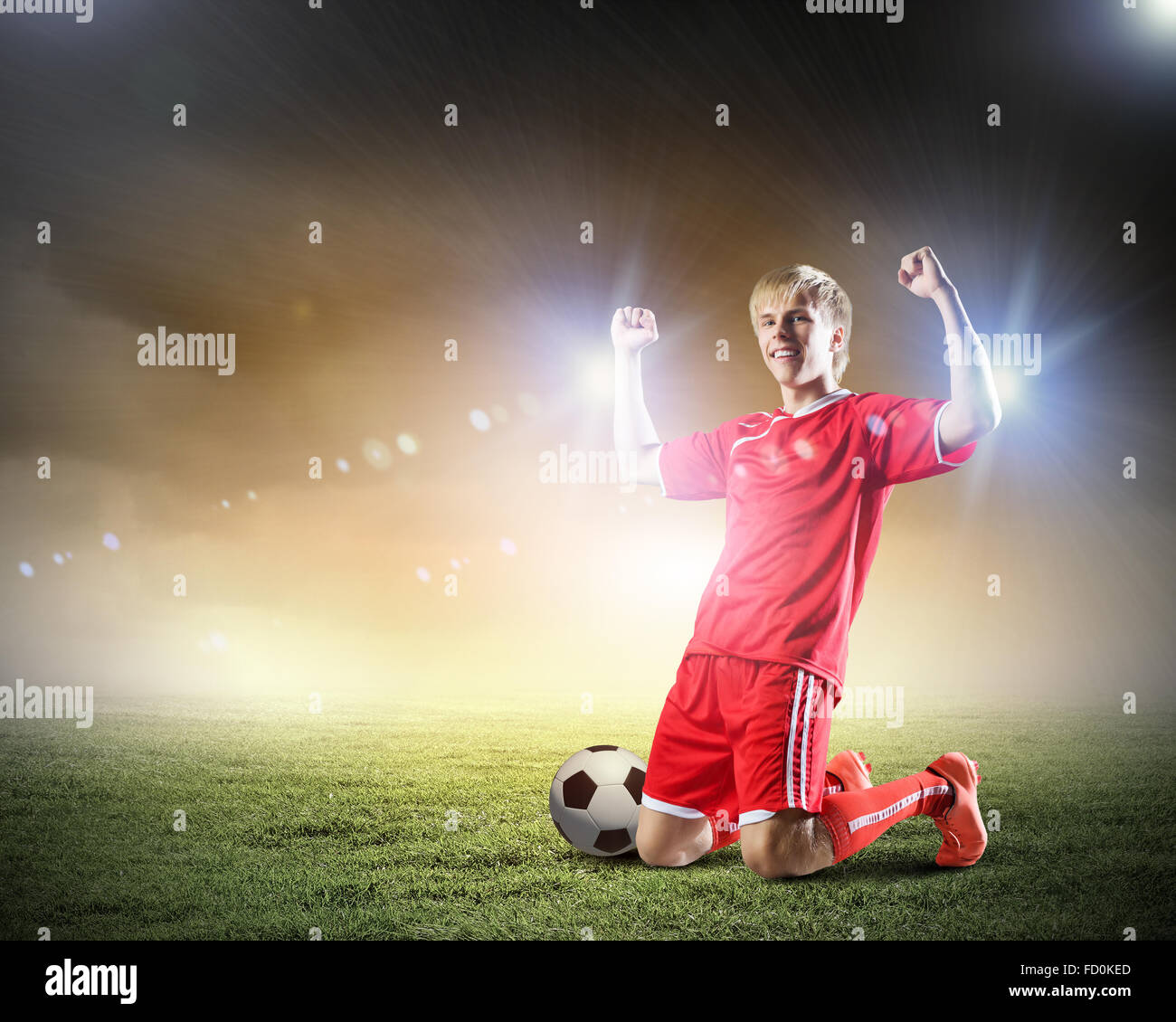 Football player standing on knees and screaming with joy Stock Photo ...