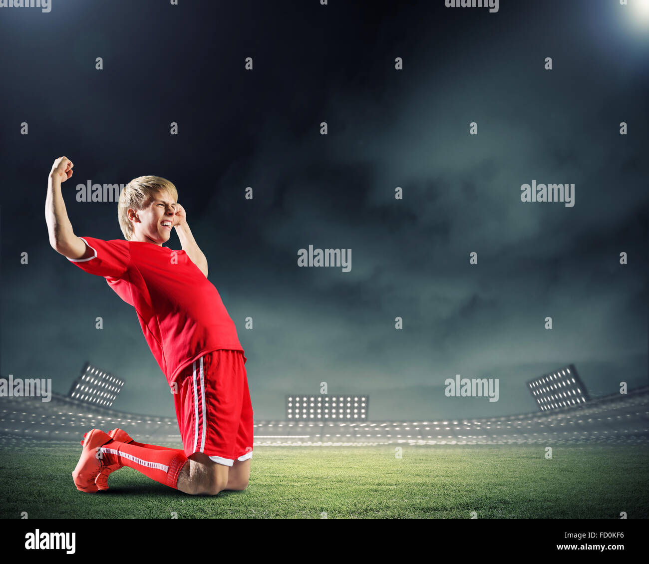 Football player standing on knees and screaming with joy Stock Photo ...