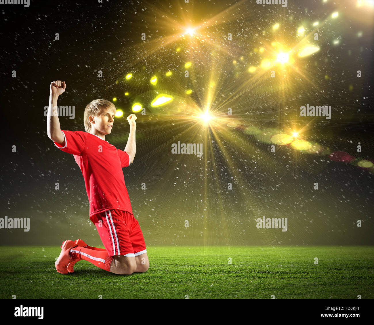 Football player standing on knees and screaming with joy Stock Photo ...