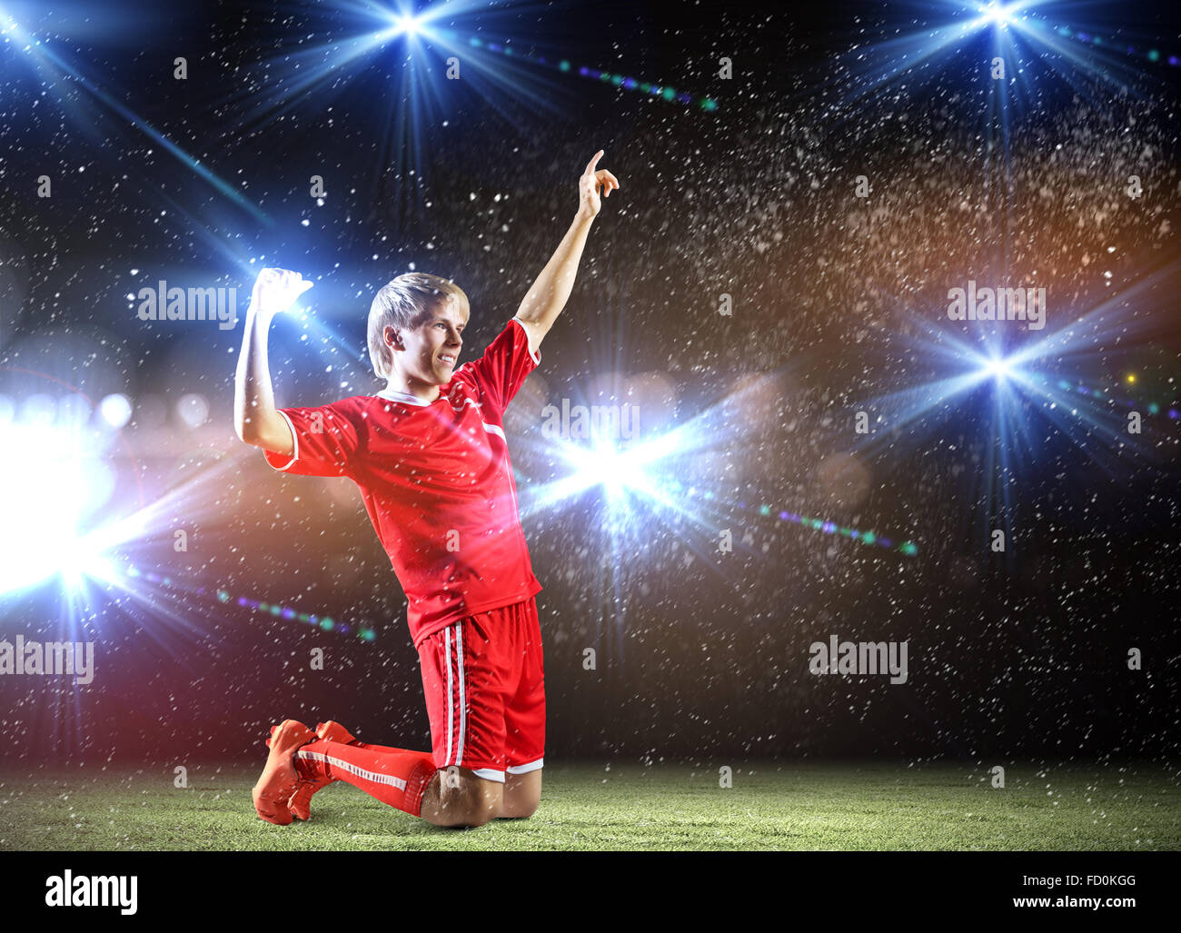 Football player standing on knees and screaming with joy Stock Photo ...