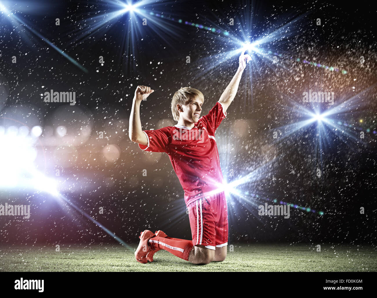 Football player standing on knees and screaming with joy Stock Photo ...