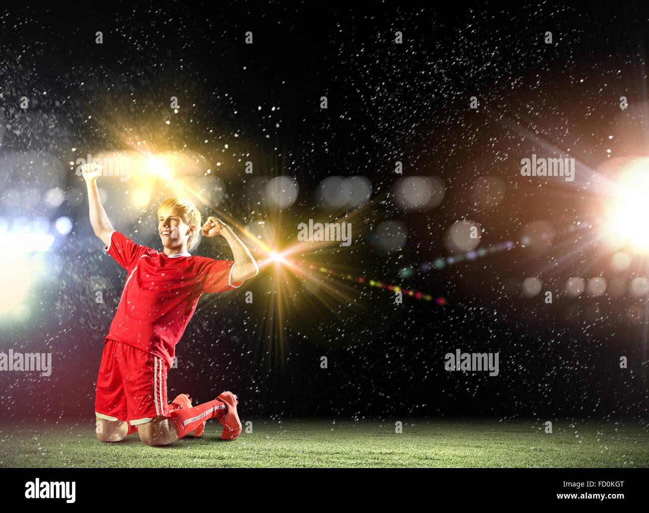 Football player standing on knees and screaming with joy Stock Photo ...