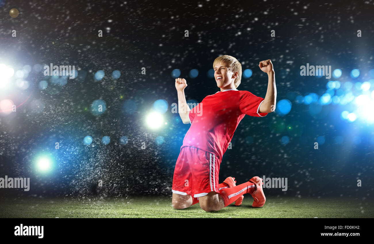Football player standing on knees and screaming with joy Stock Photo ...