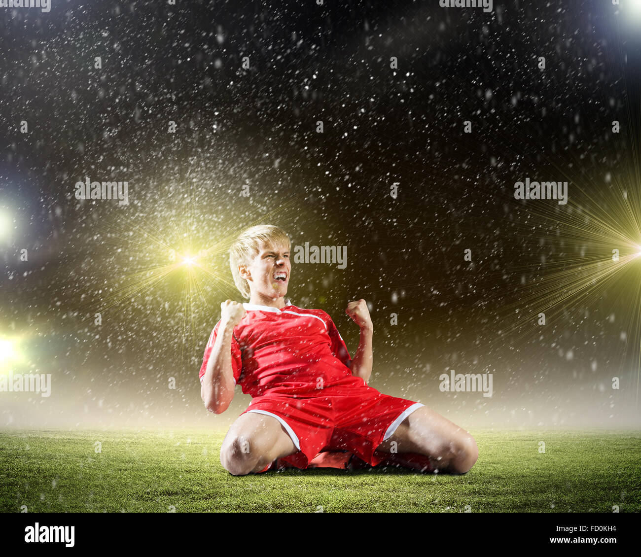 Football player standing on knees and screaming with joy Stock Photo ...