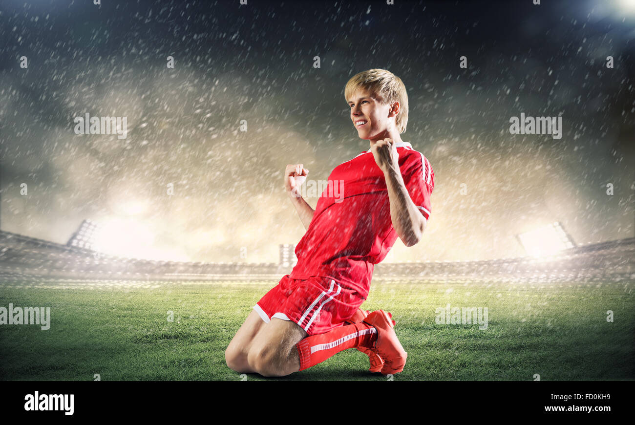 Football player standing on knees and screaming with joy Stock Photo ...