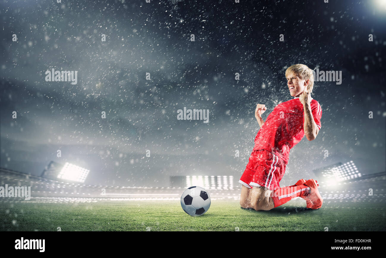Football player standing on knees and screaming with joy Stock Photo ...