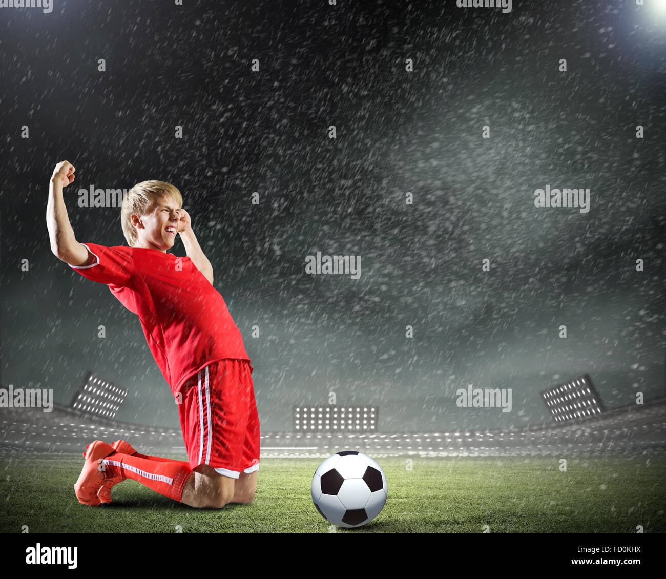 Football player standing on knees and screaming with joy Stock Photo ...
