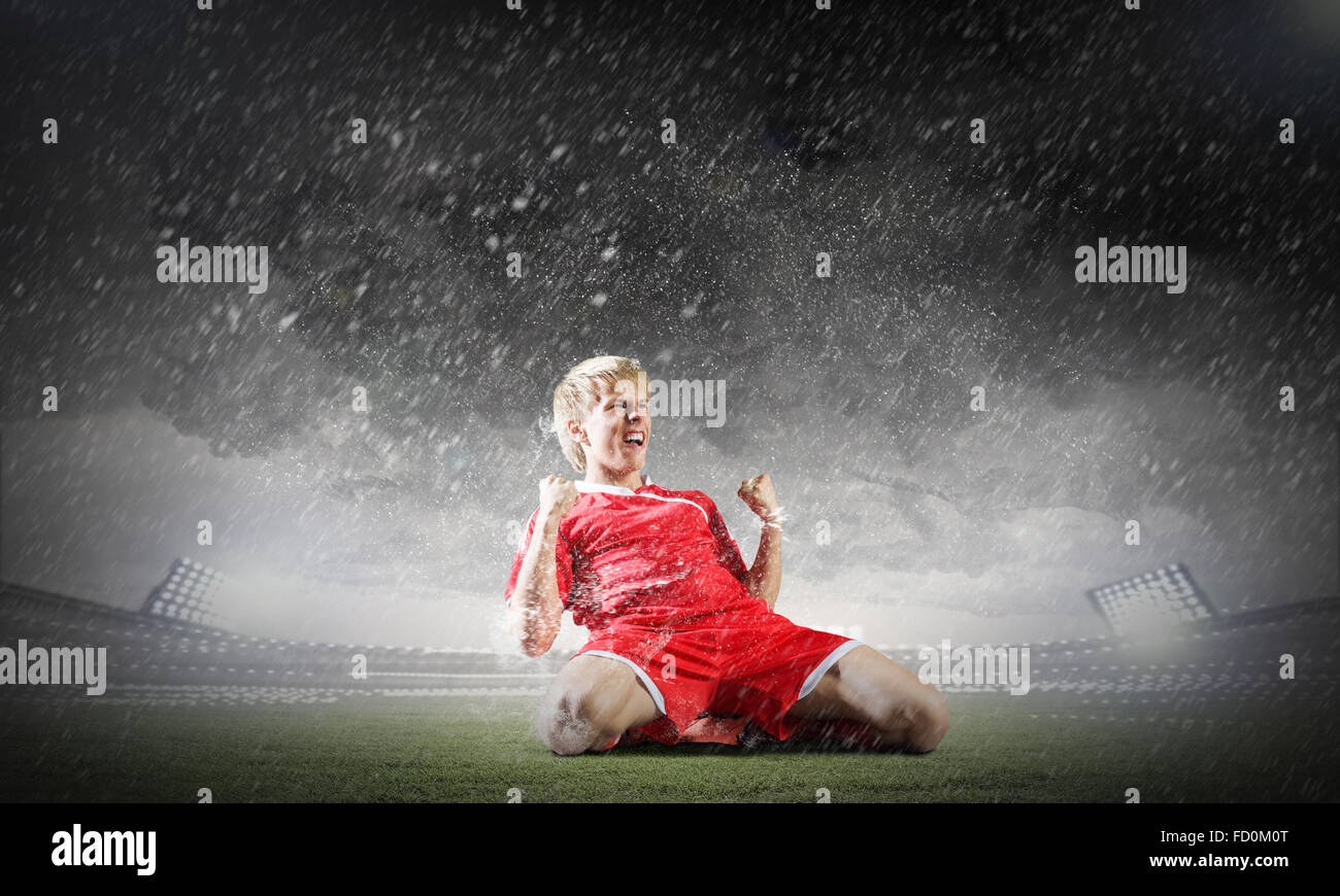 Football player standing on knees and screaming with joy Stock Photo ...