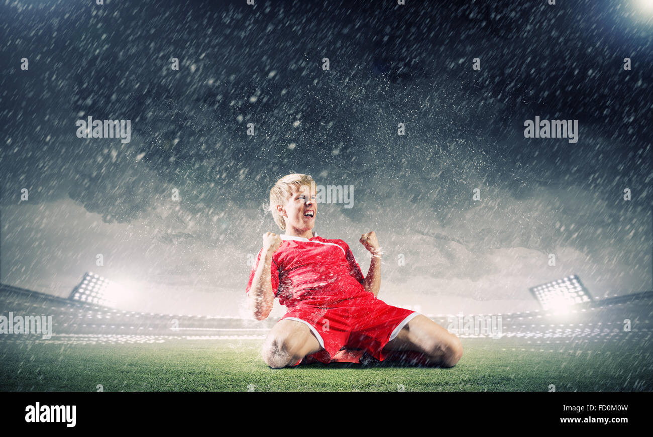 Football player standing on knees and screaming with joy Stock Photo ...