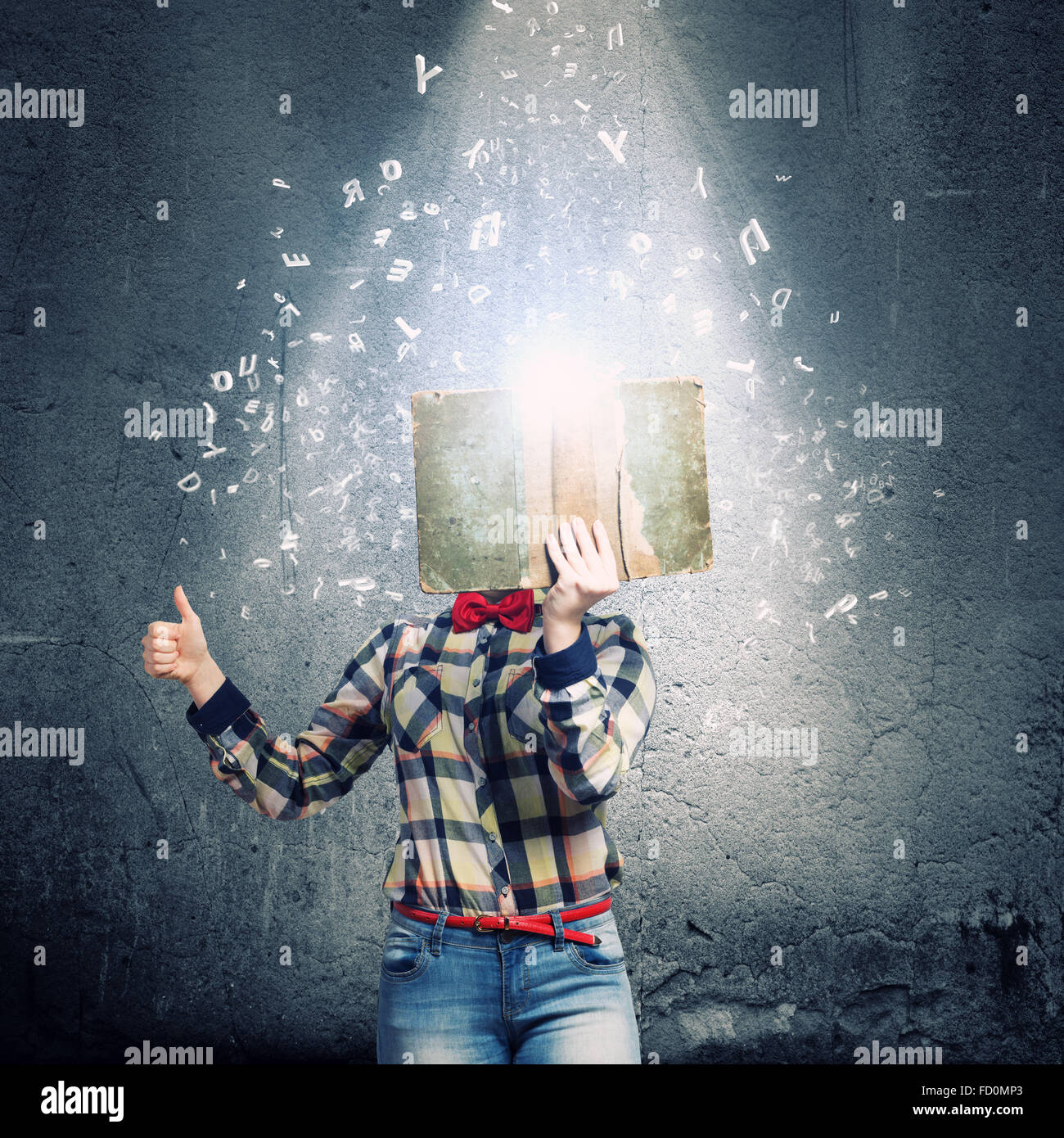 Woman in casual wear hiding her face behind book Stock Photo - Alamy