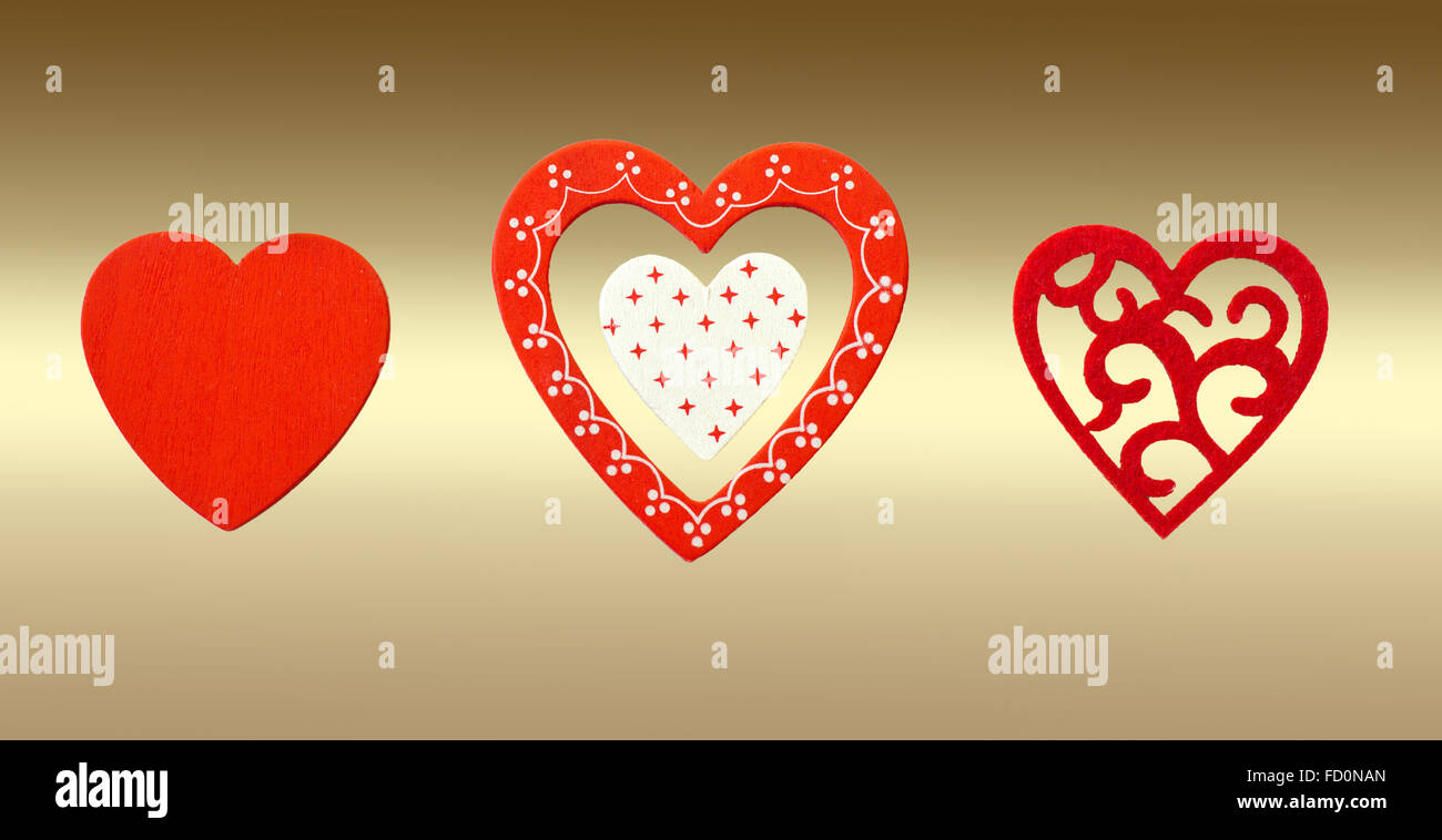A photo of three different heart designs on golden background Stock ...
