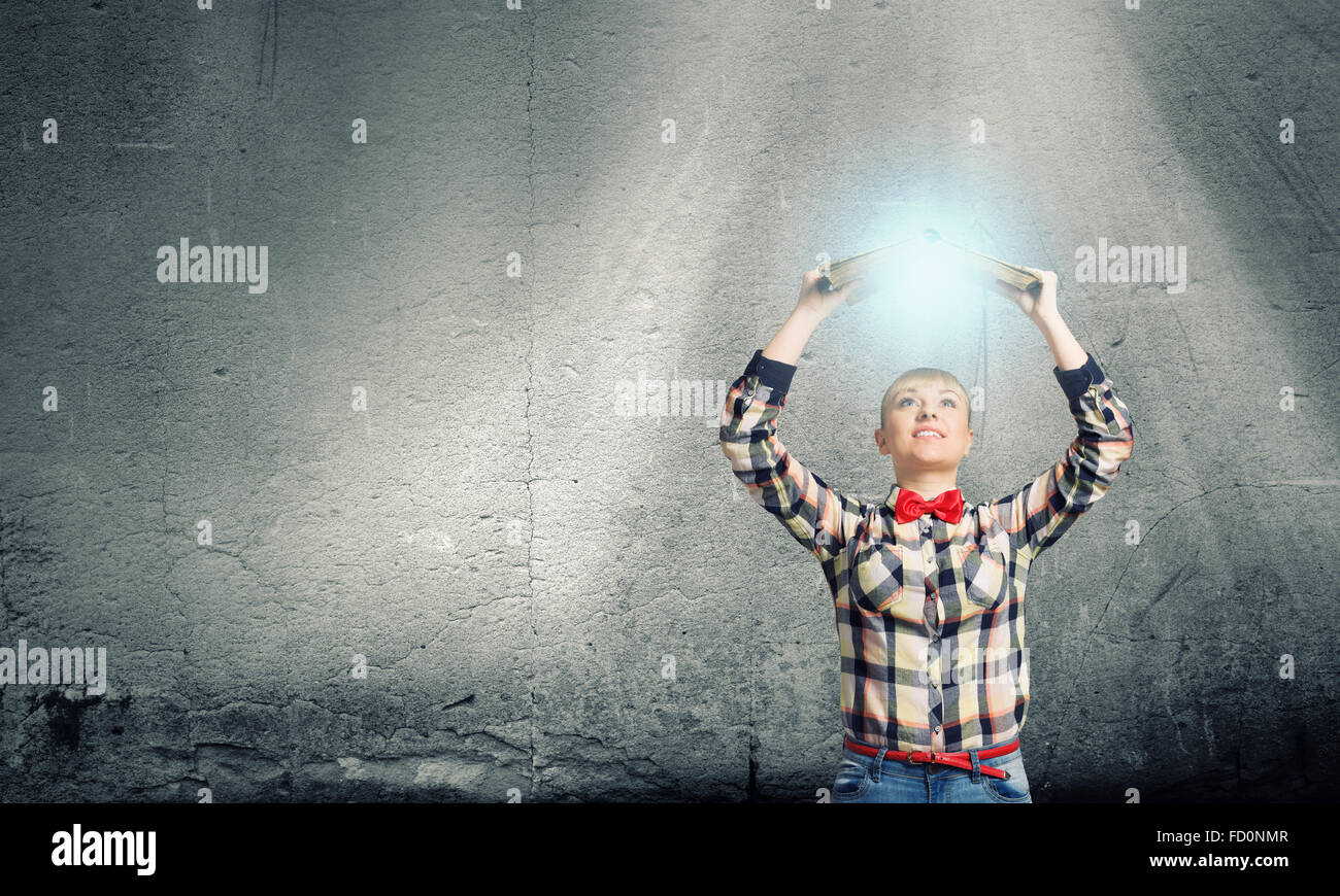 Young woman in shirt holding book above head Stock Photo - Alamy