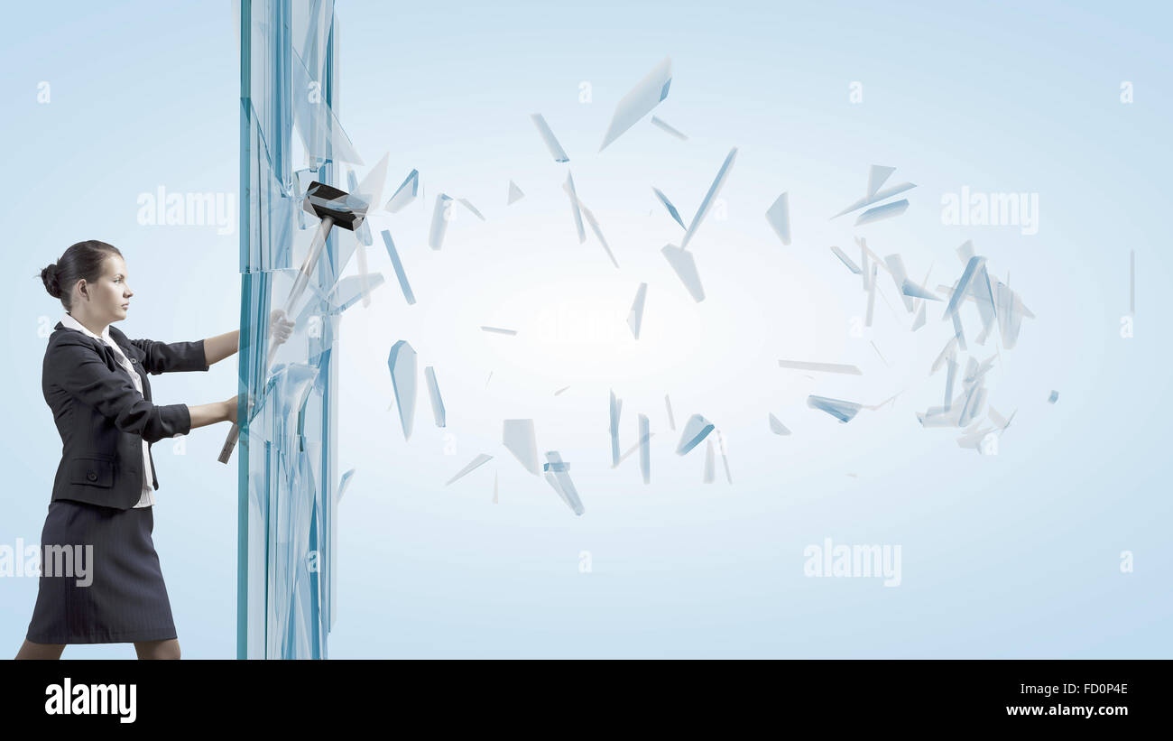 Young determined businesswoman breaking glass with hammer Stock Photo ...