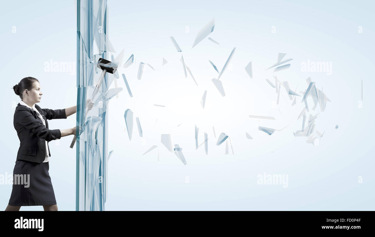 Young determined businesswoman breaking glass with hammer Stock Photo ...