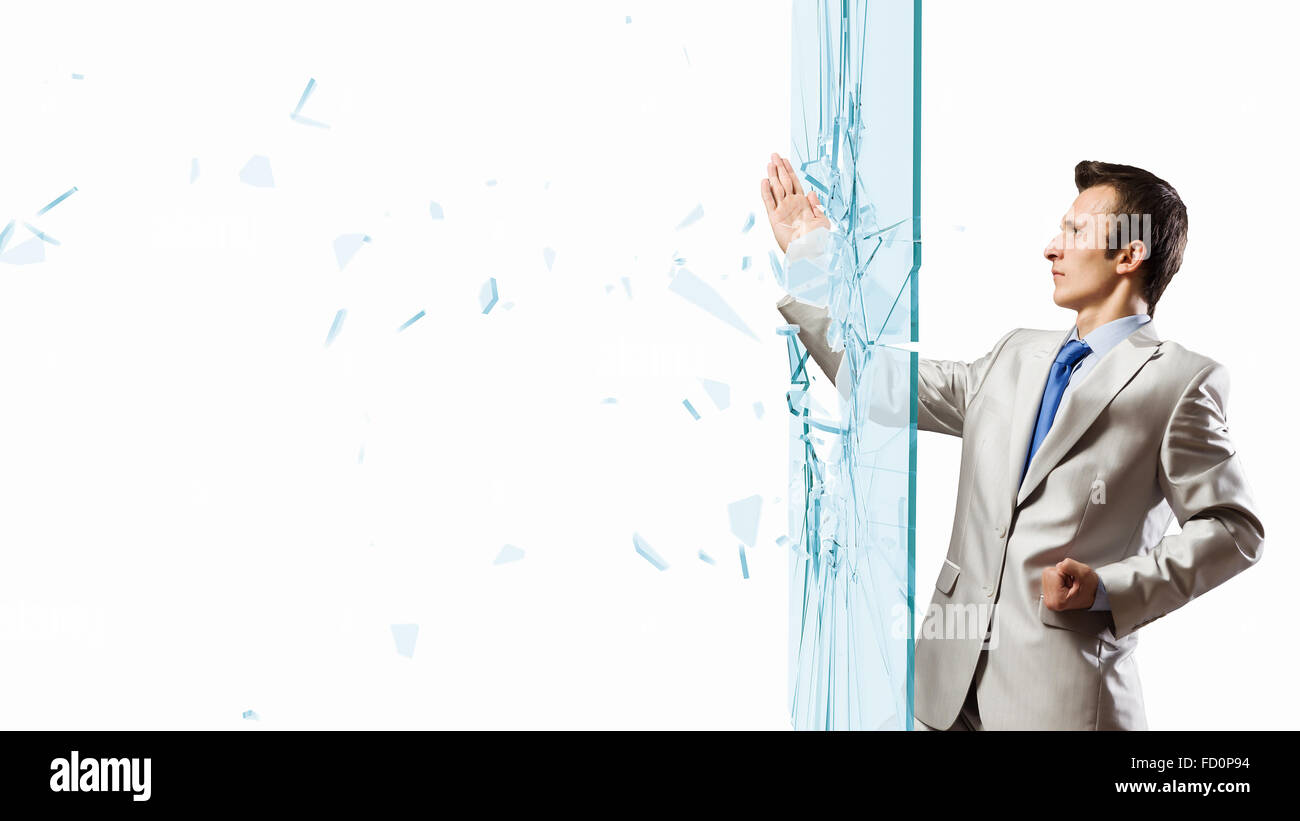 Young determined businessman breaking glass with karate punch Stock ...