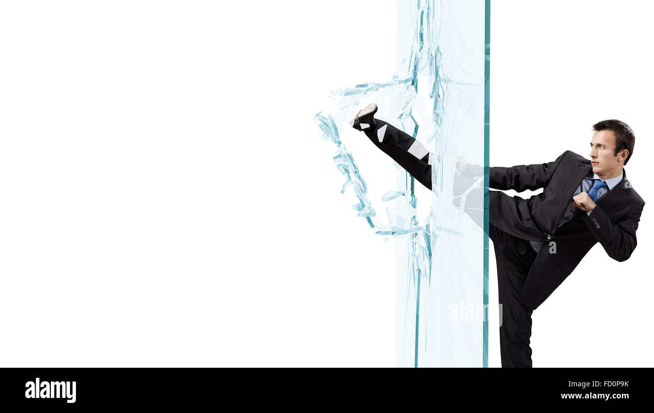 Young determined businessman breaking glass with karate kick Stock ...
