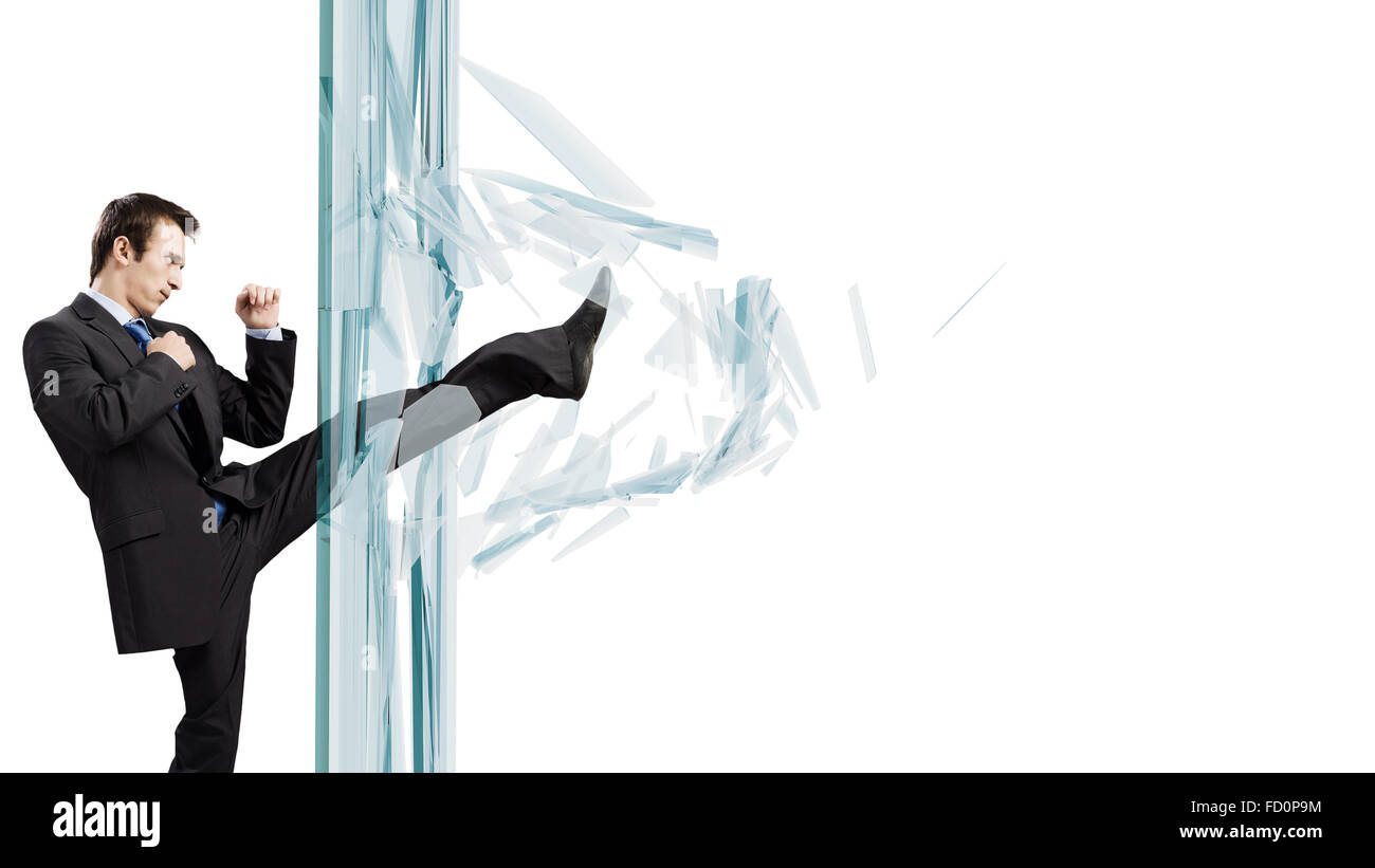 Young determined businessman breaking glass with karate kick Stock ...