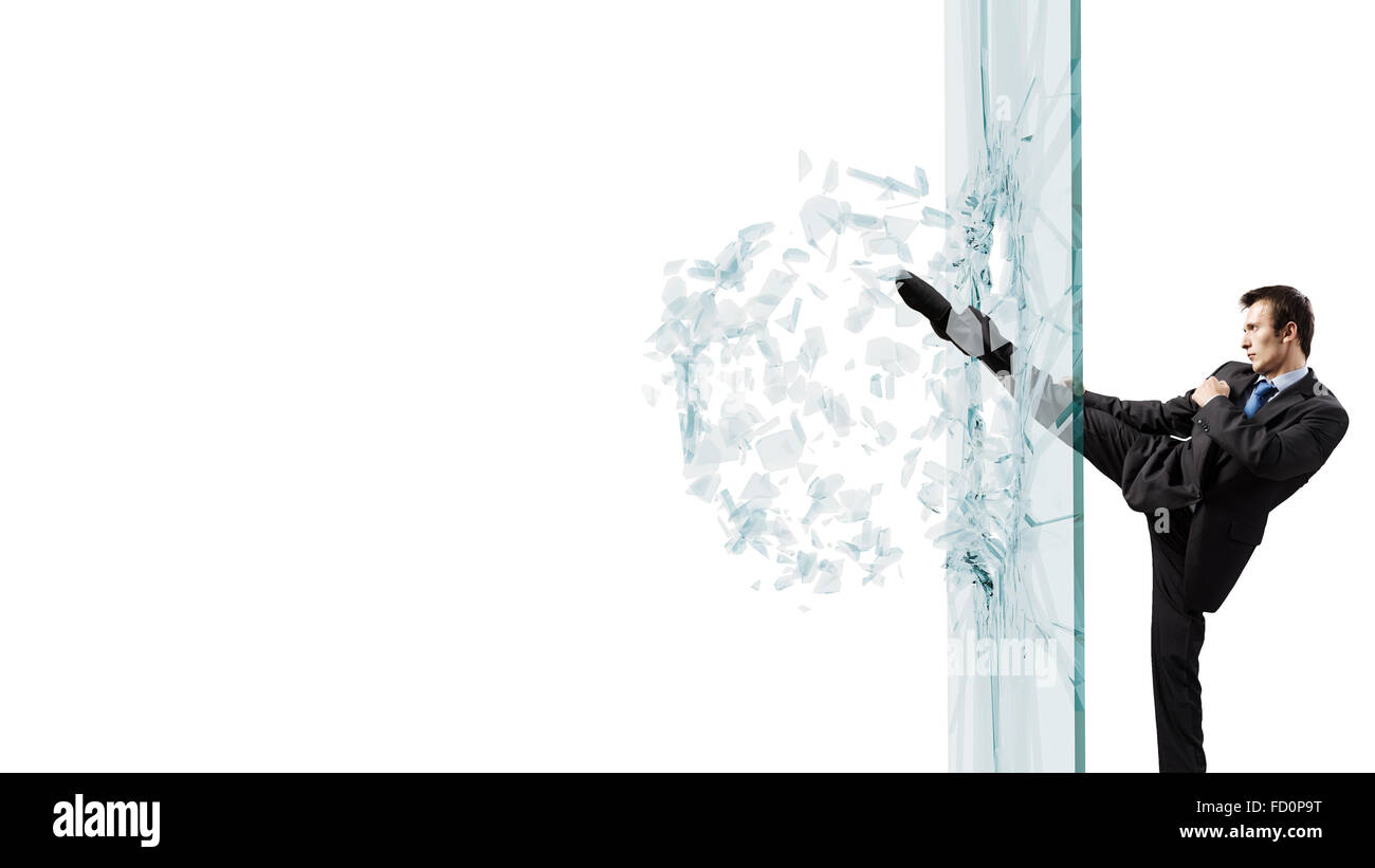 Young determined businessman breaking glass with karate kick Stock ...