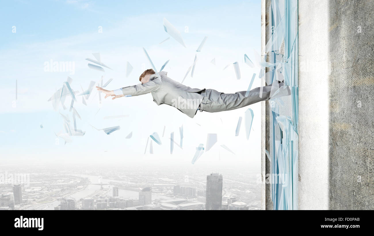 Businessman jumping through glass window of office Stock Photo - Alamy