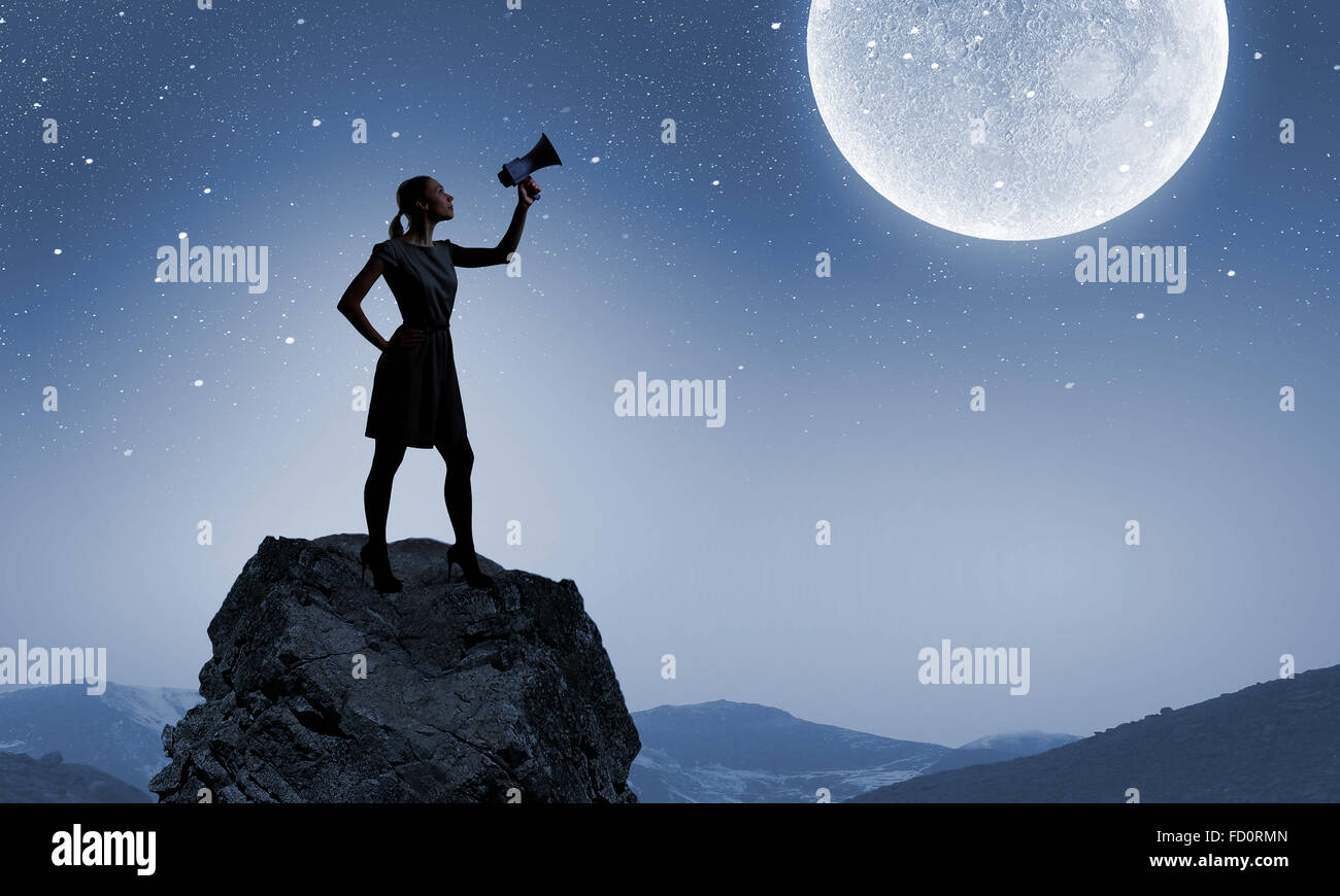 Silhouette of woman on top of rock screaming in megaphone Stock Photo ...