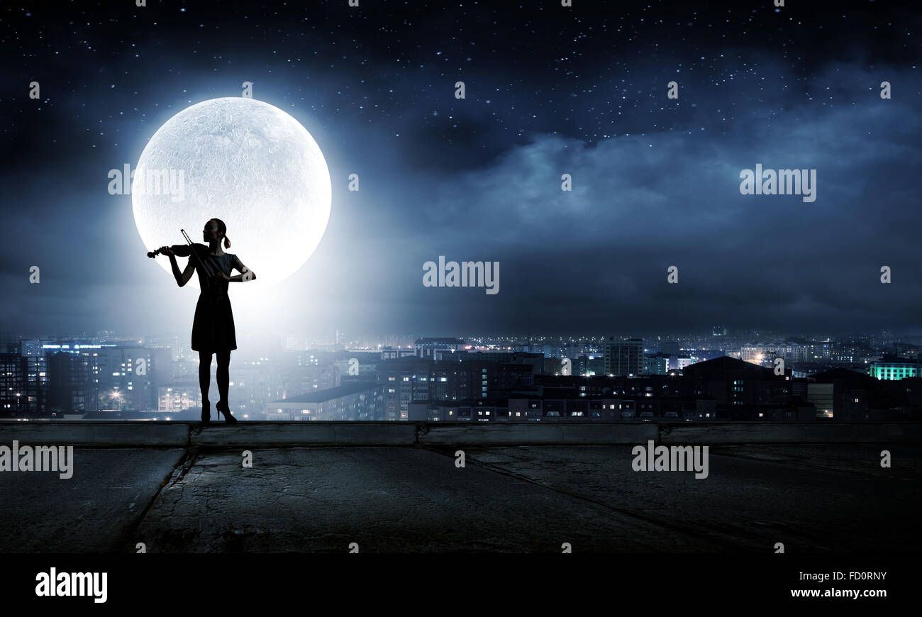Silhouette of woman playing violin at night Stock Photo - Alamy