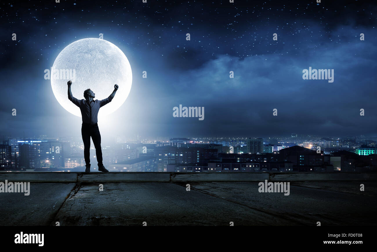 Young man at night with big full moon at background Stock Photo - Alamy