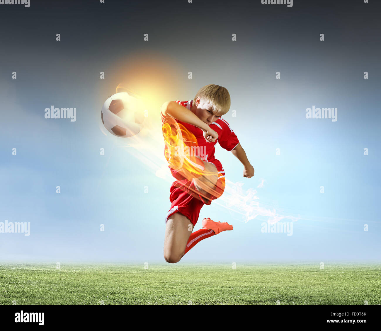 Young football player on stadium kicking ball in jump hi-res stock ...
