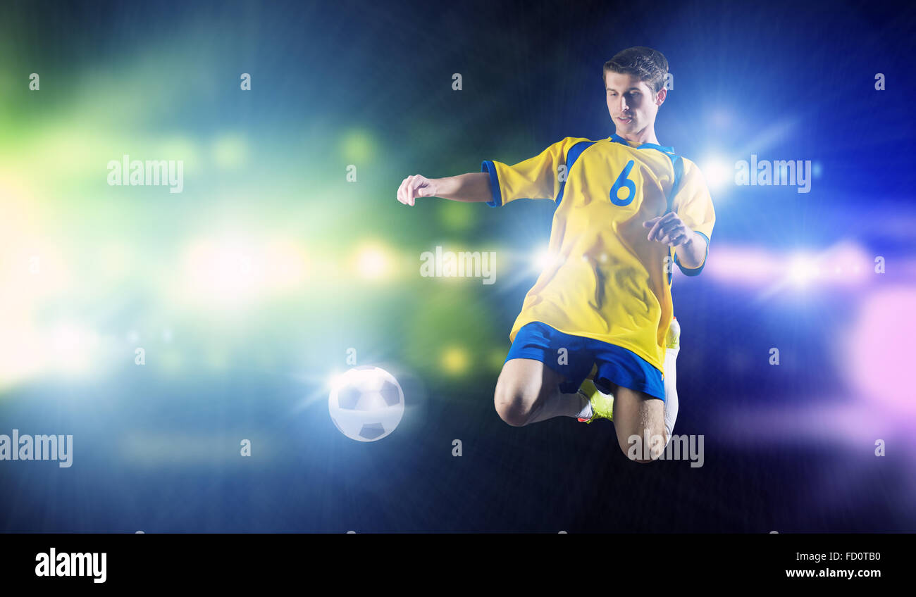 Young football player on stadium in jump taking ball Stock Photo - Alamy