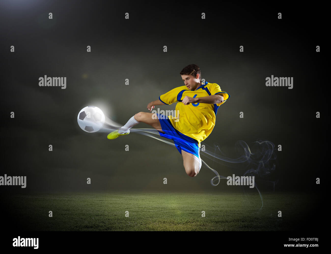 Young football player on stadium in jump taking ball Stock Photo - Alamy