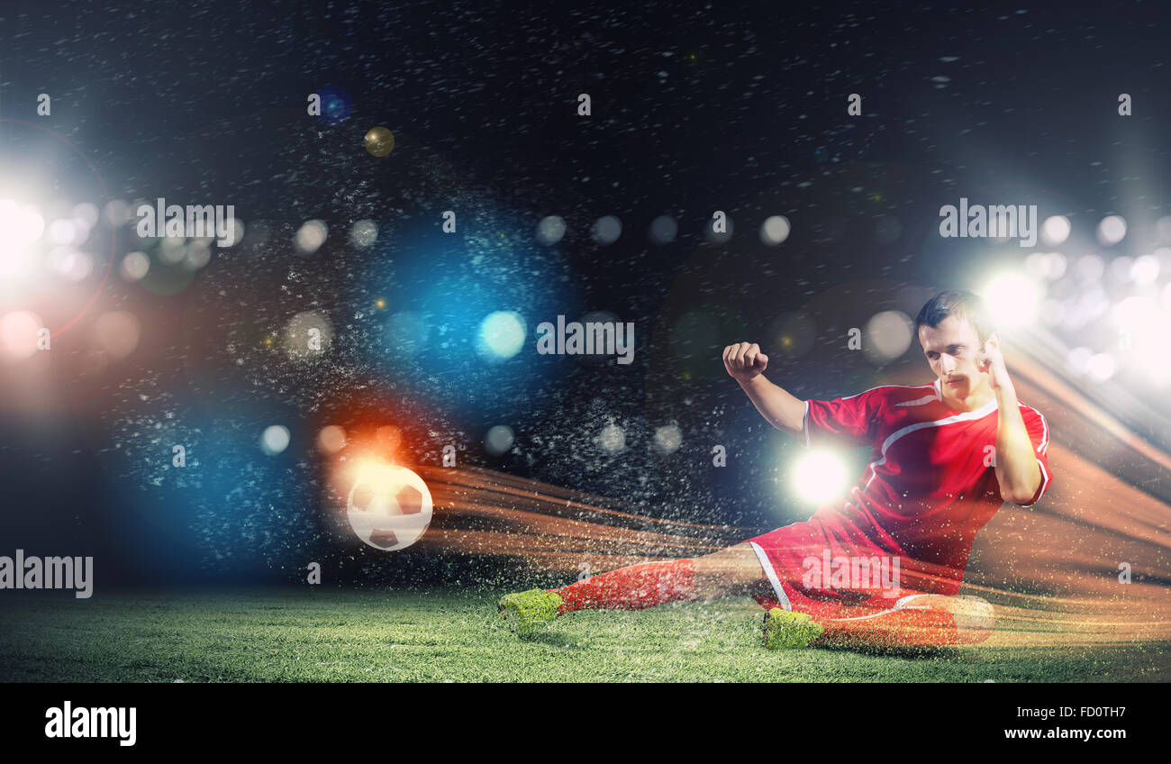Young football player on stadium doing slide tackle Stock Photo - Alamy
