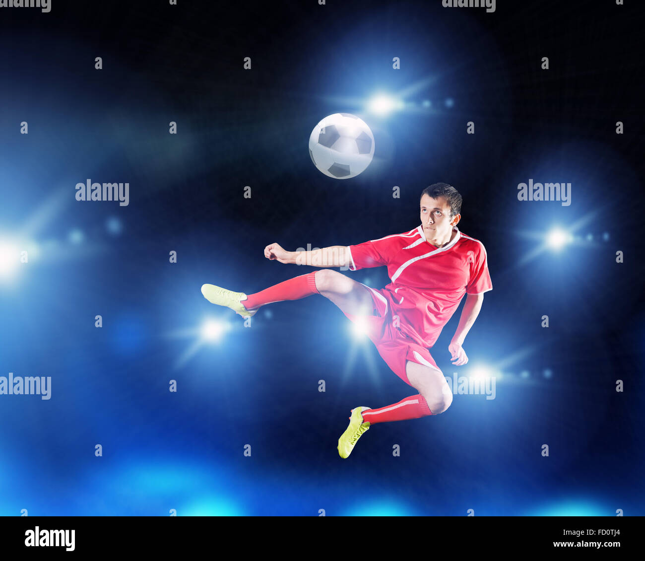 Young football player on stadium in jump taking ball Stock Photo - Alamy