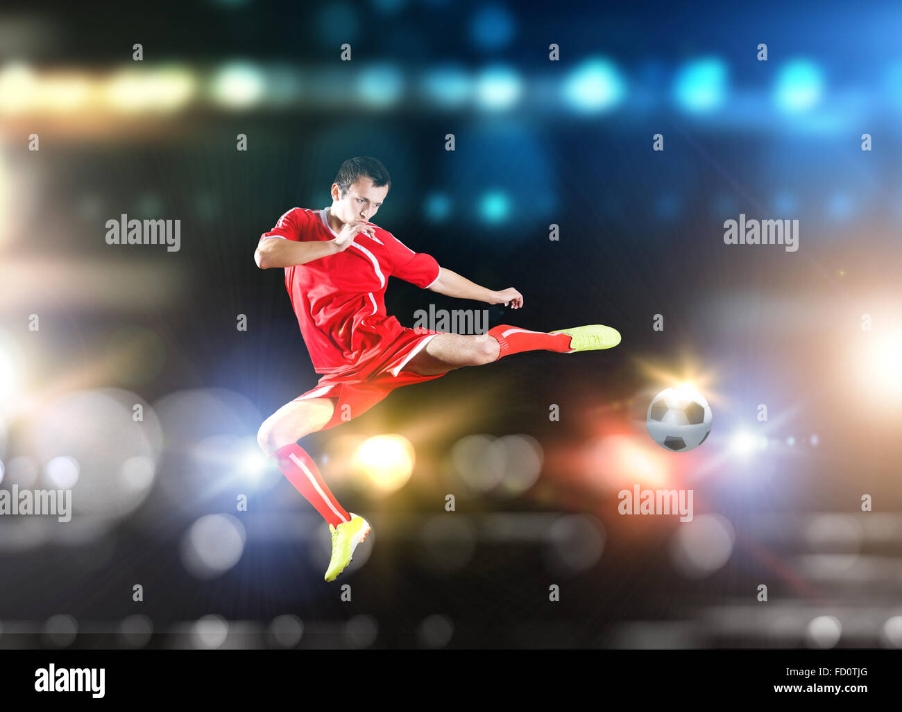 Young football player on stadium in jump taking ball Stock Photo - Alamy
