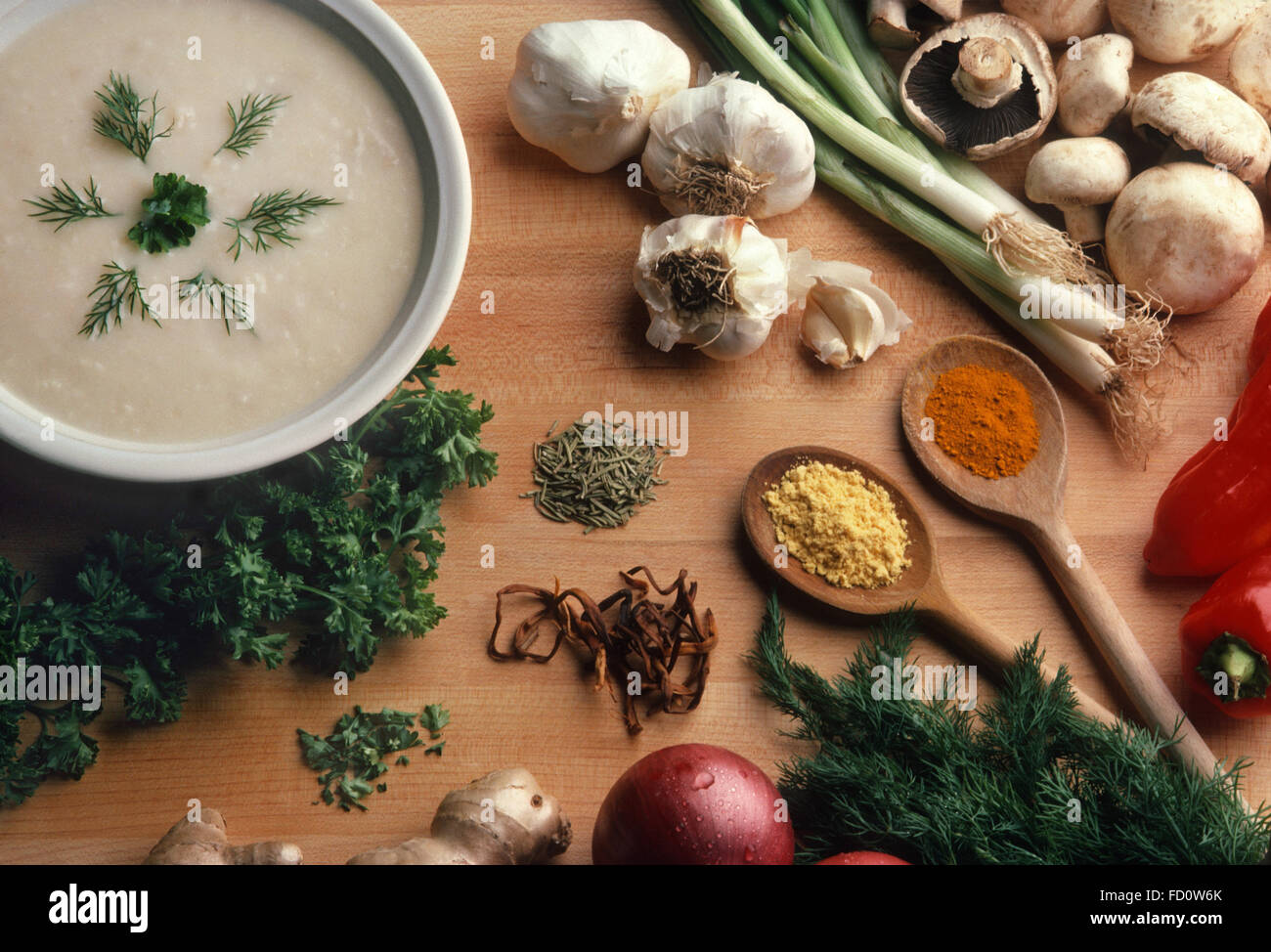 Creamy soup surrounded by ingredients on a butcher block surface Stock ...
