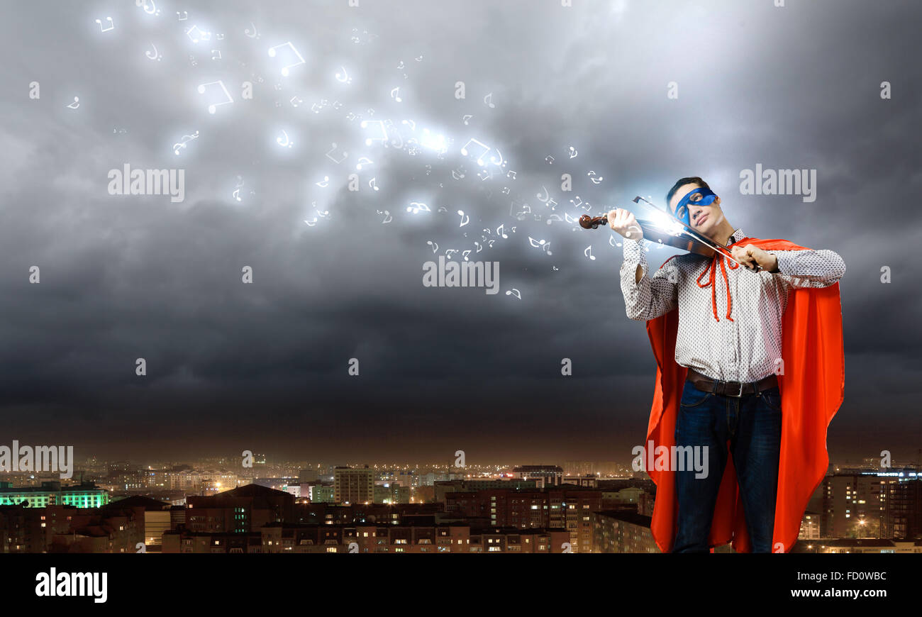 Young man in superhero costume playing violin hi-res stock photography ...