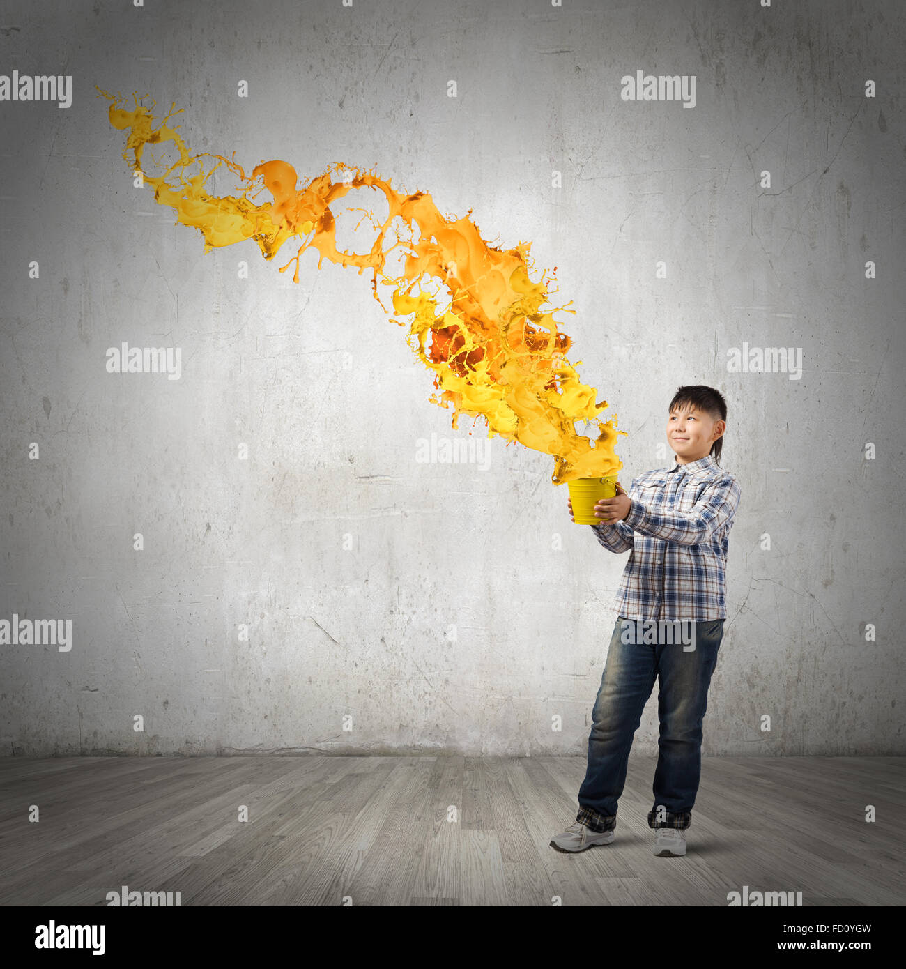 Young boy splashing colorful paint from bucket Stock Photo - Alamy